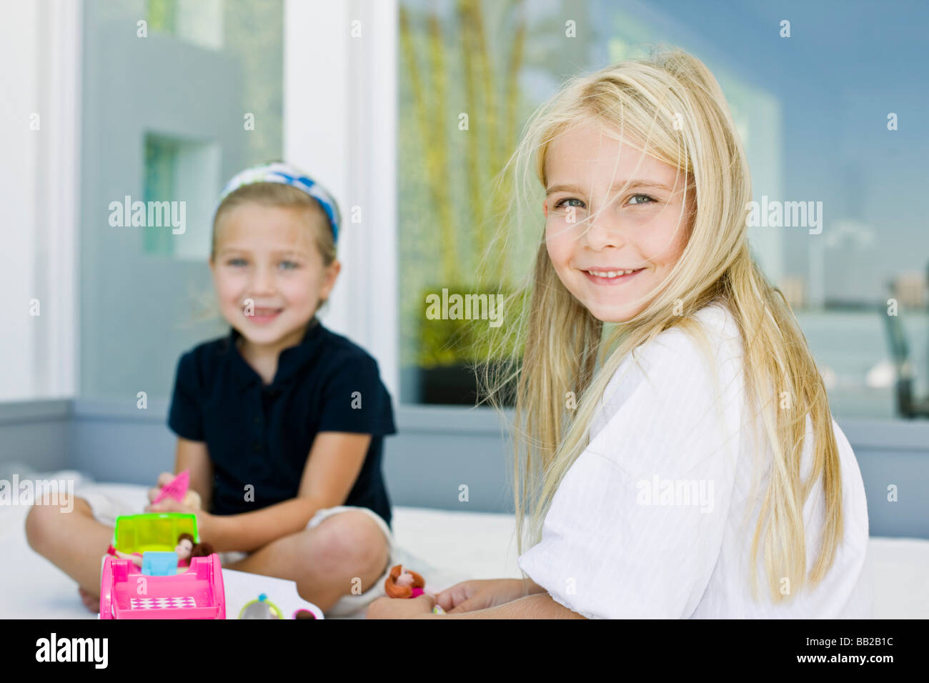 Portrait of two girls playing with toys Stock Photo - Alamy