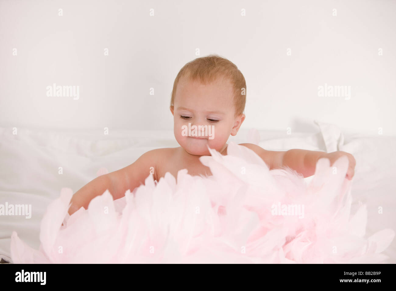Baby girl playing with feathers Stock Photo - Alamy