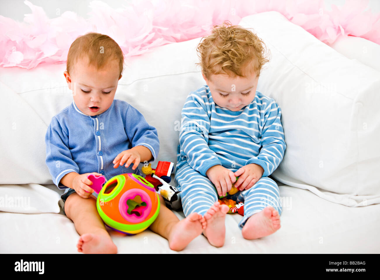 Two babies playing with toys Stock Photo - Alamy