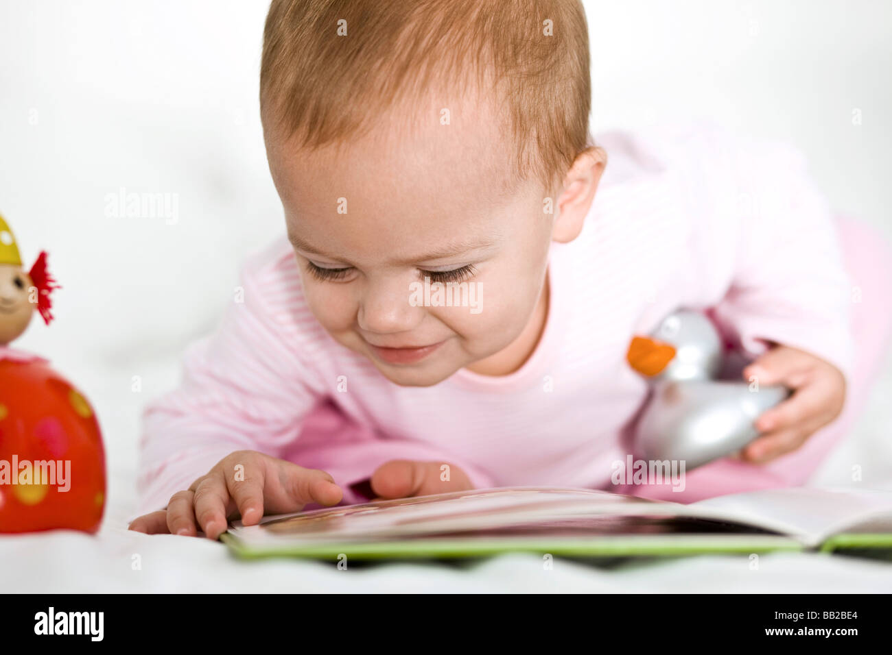 Baby girl looking at a picture book Stock Photo - Alamy