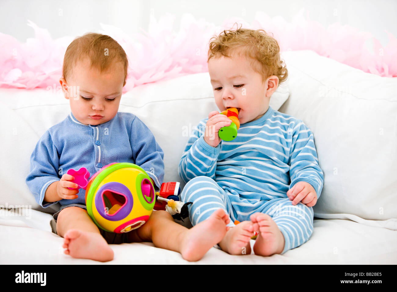 Two babies playing with toys Stock Photo - Alamy