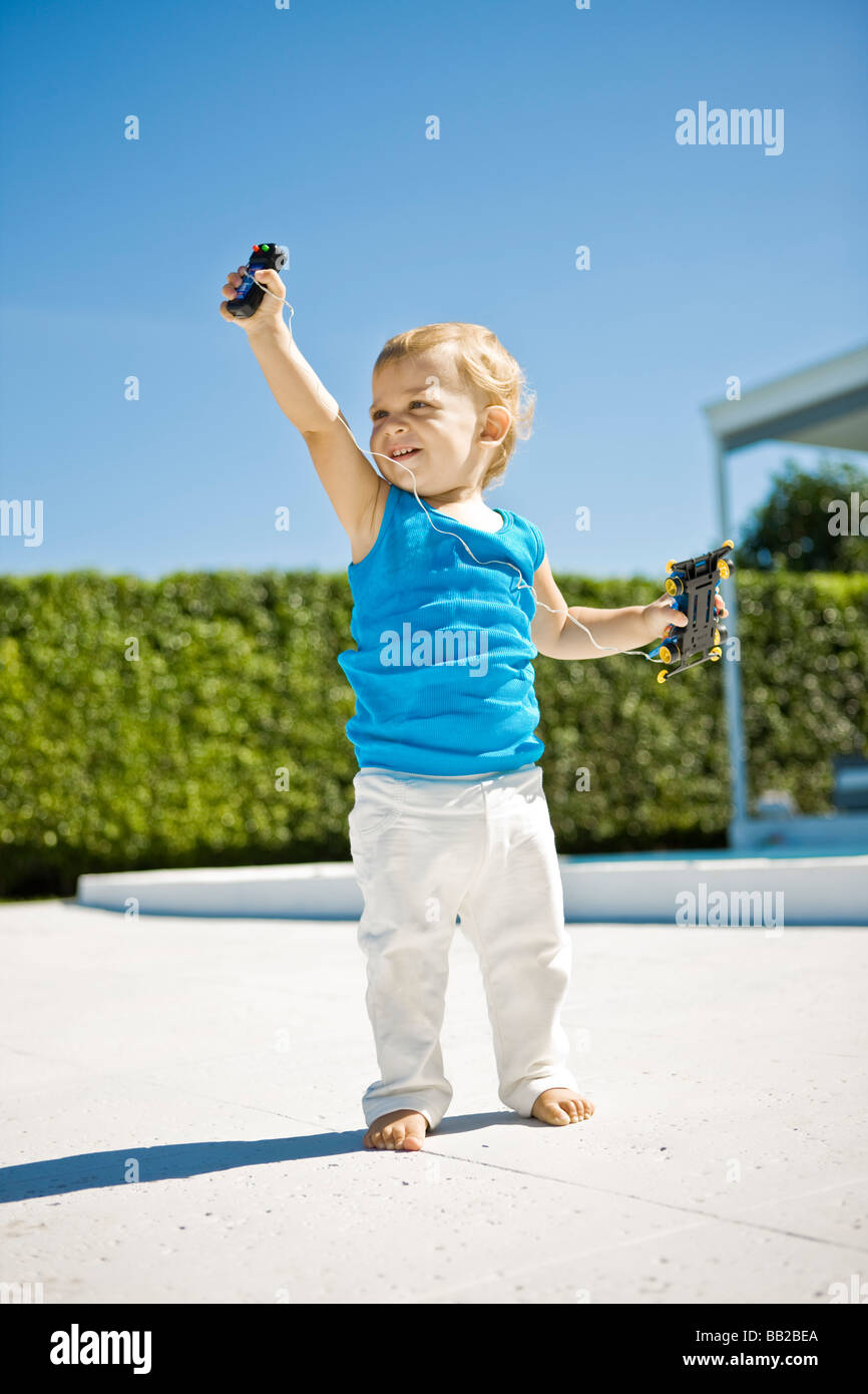 Baby boy holding a remote controlled car and smiling Stock Photo - Alamy