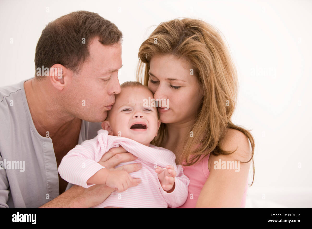 Parents consoling their crying daughter Stock Photo - Alamy