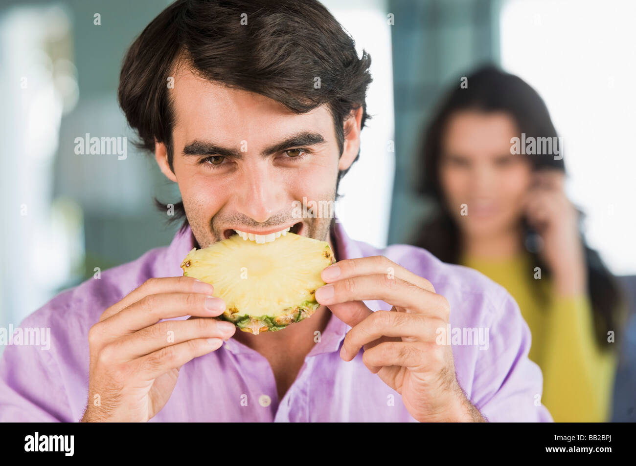 Man eating a pineapple slice Stock Photo - Alamy