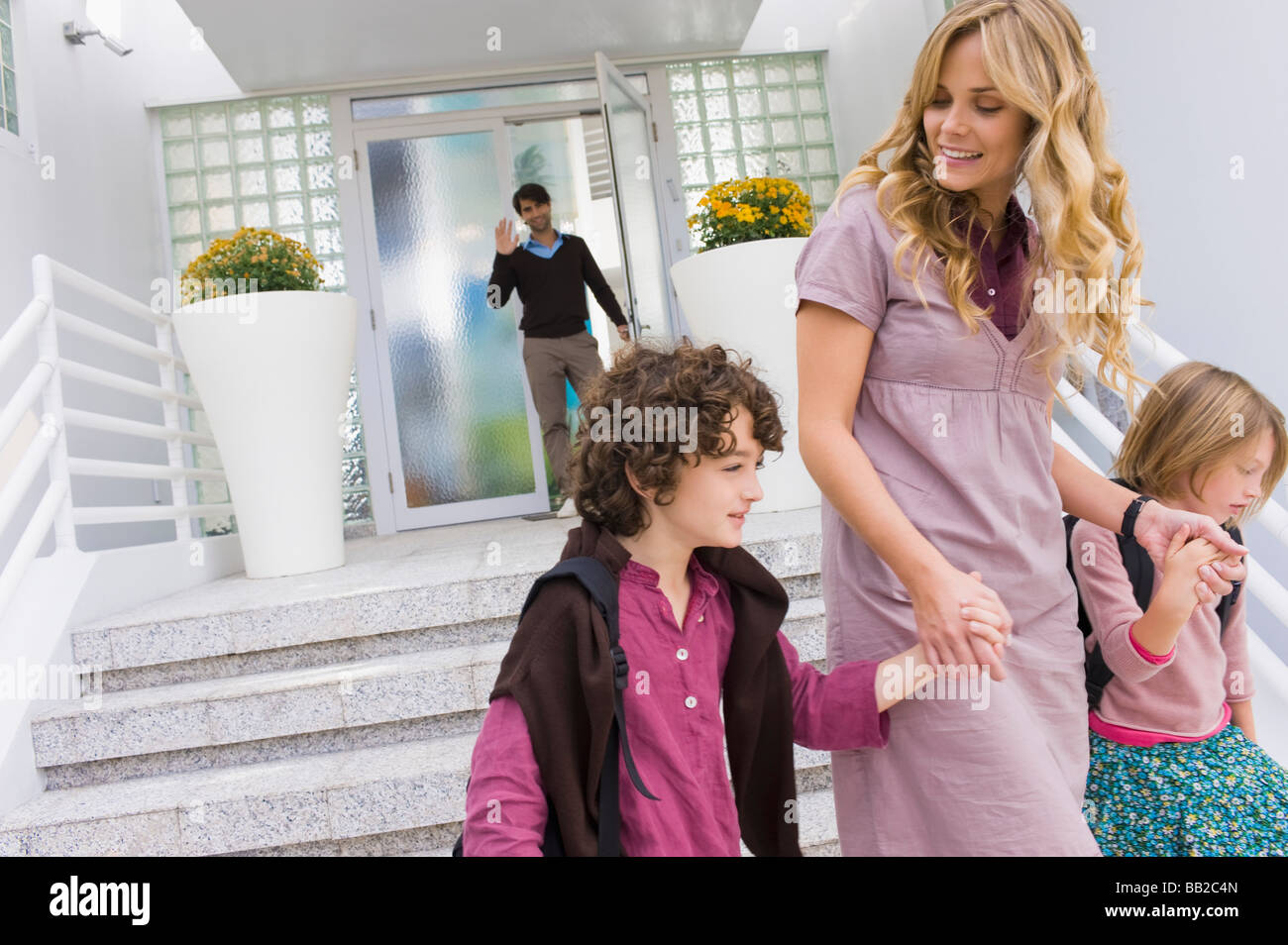 Woman with her children leaving for school Stock Photo - Alamy