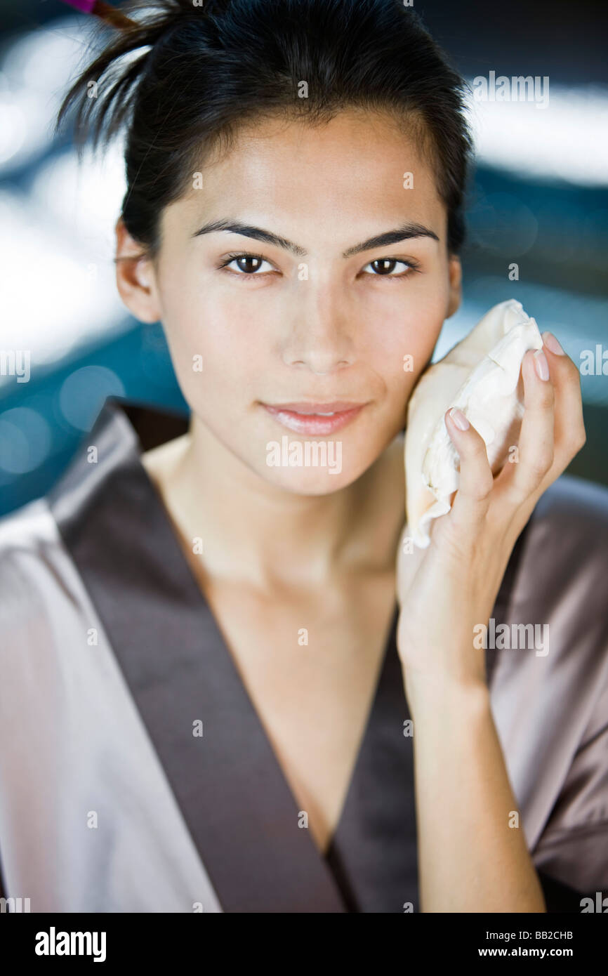 Portrait of a woman touching a conch shell on her face Stock Photo - Alamy
