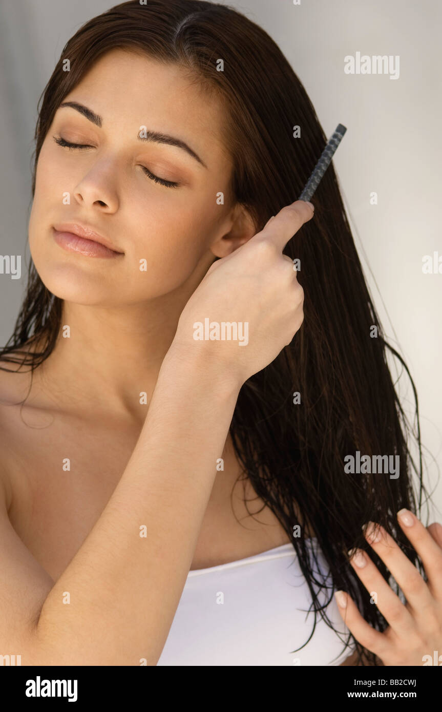 Close-up of a woman combing her hair Stock Photo - Alamy