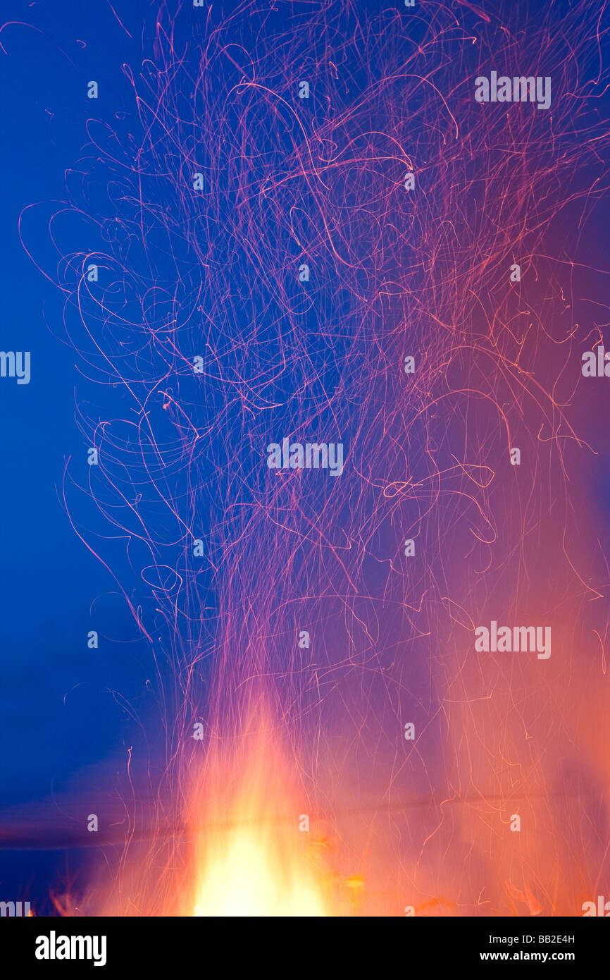 RED AND ORANGE LIGHT TRAILS FROM BONFIRE AGAINST BLUE SKY Stock Photo ...