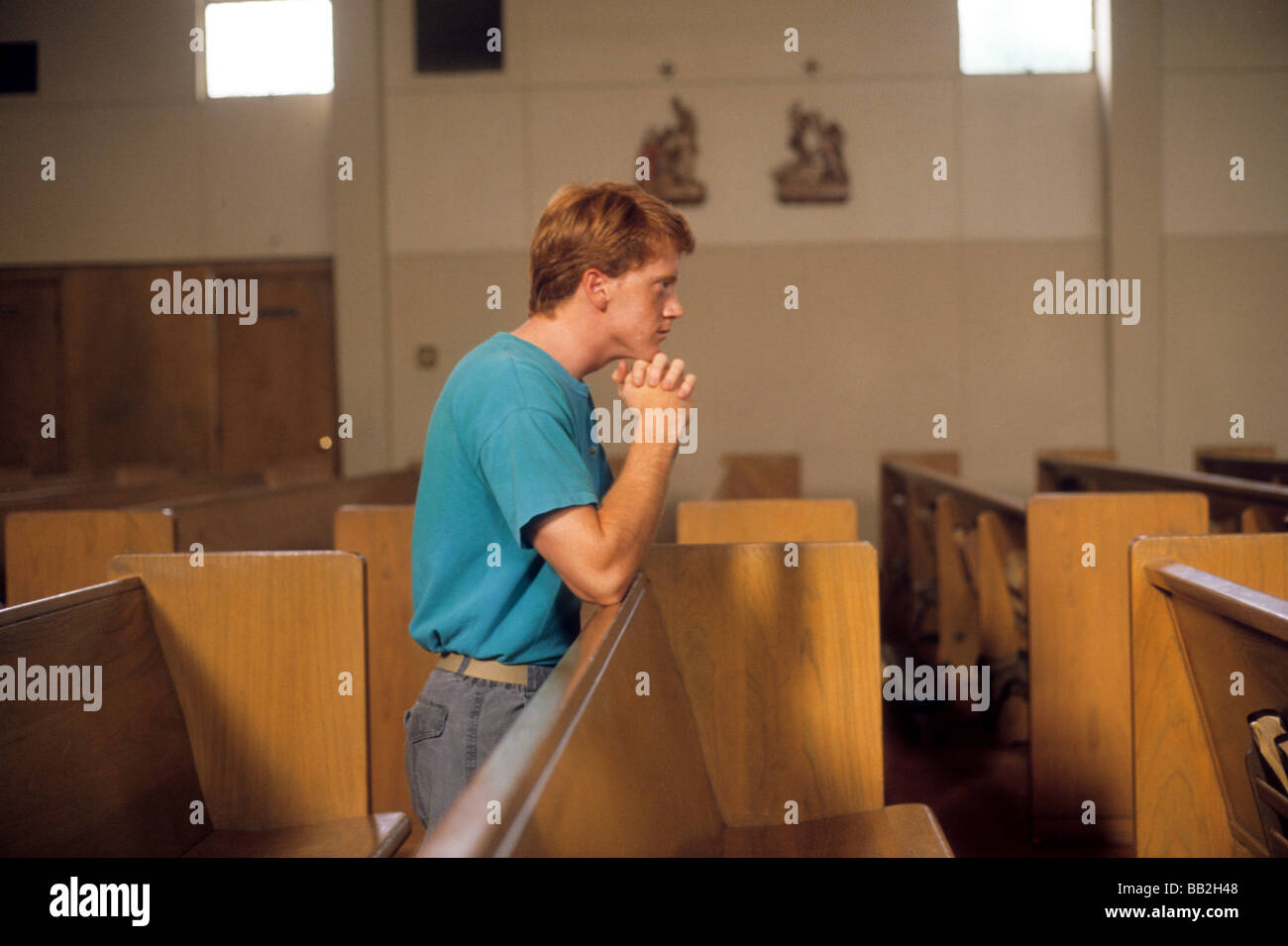 Teen boy pray church catholic religion Stock Photo - Alamy