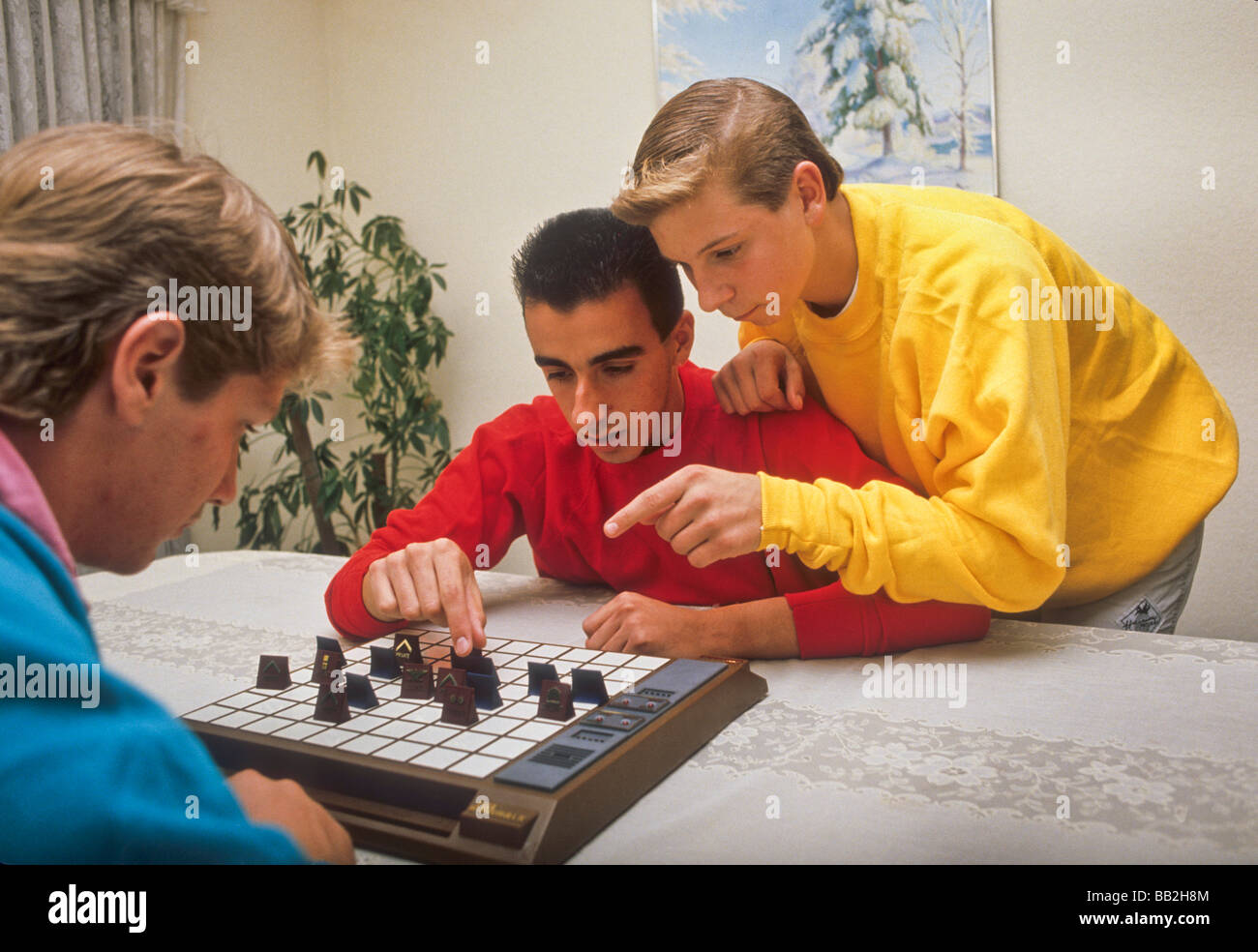 Three teen boy friend play game share fun interest hobby compete try ...