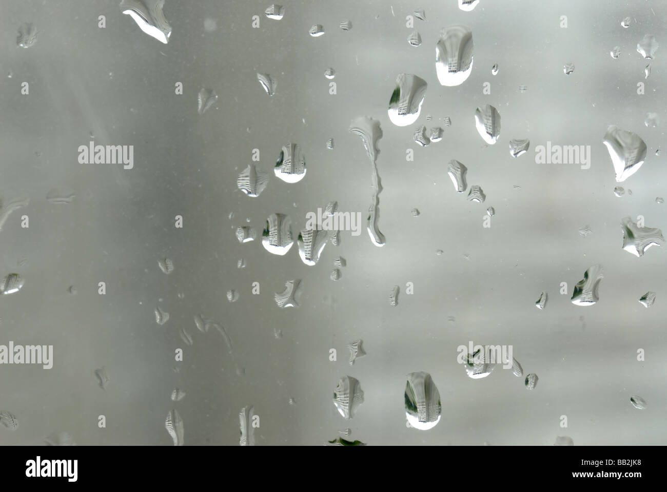 Rain drops with reflections of building on the glass window Stock Photo ...