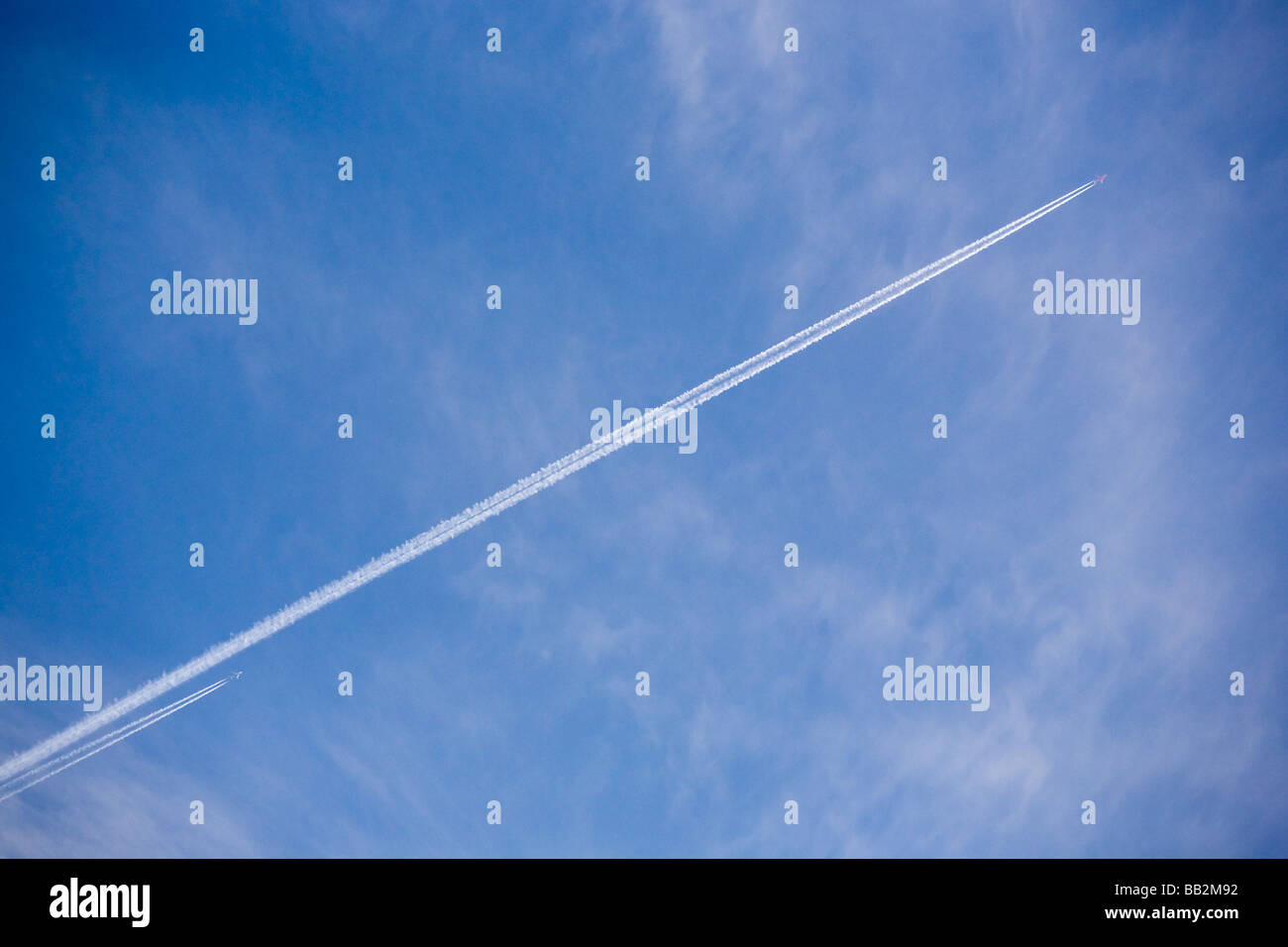 Vapor trail of two passenger aircraft flying parallel flight paths ...
