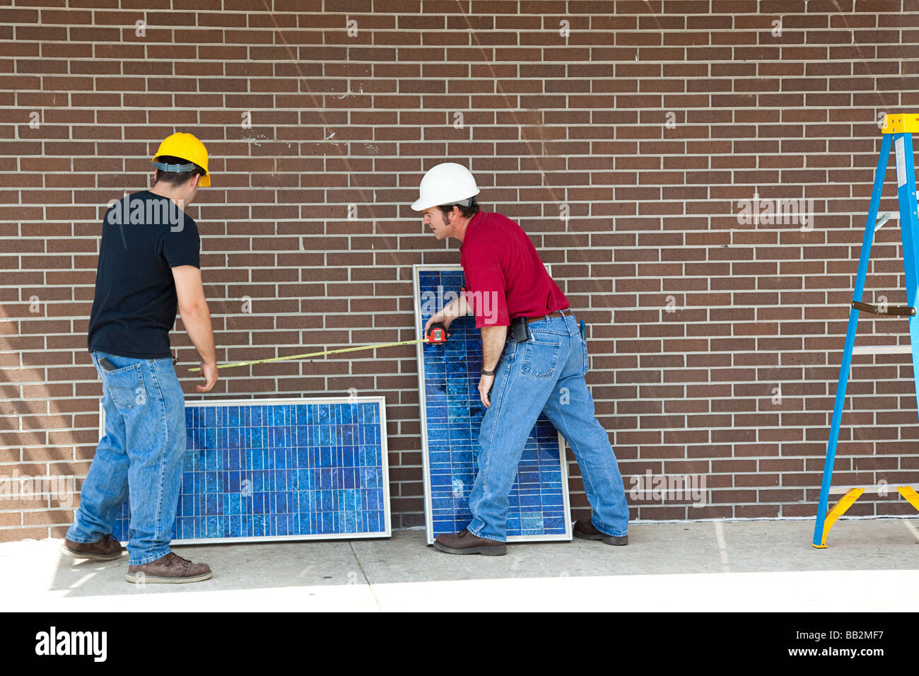 Workers measuring and installing solar electric panels Stock Photo - Alamy