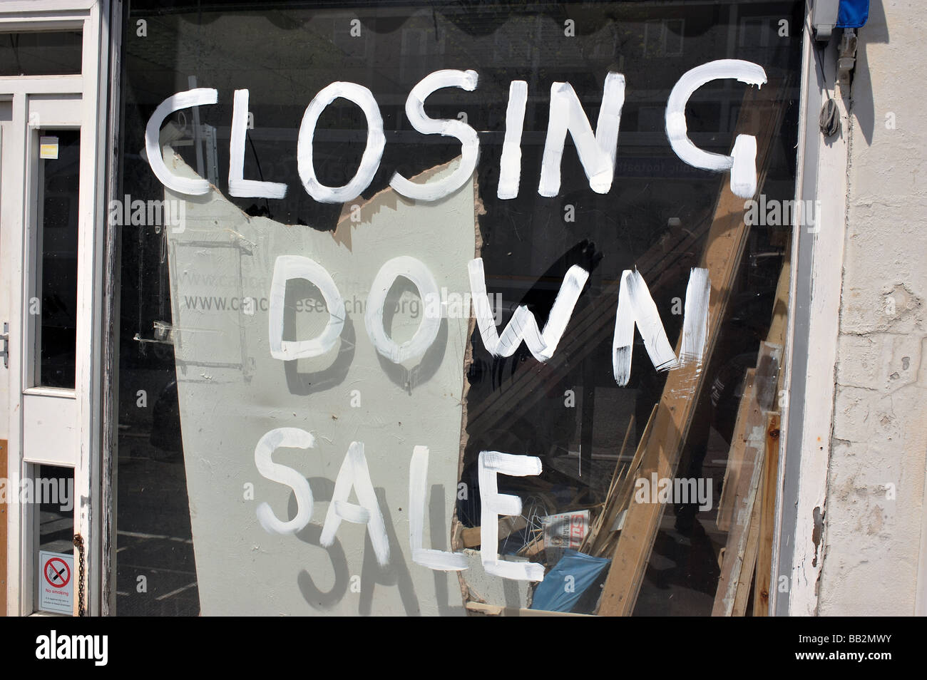 A closing down sign painted in a shop window Stock Photo - Alamy