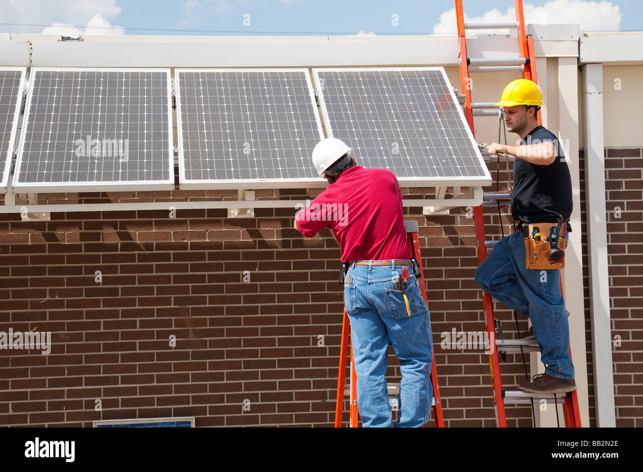 Two electricians installing solar panels on a building Stock Photo - Alamy