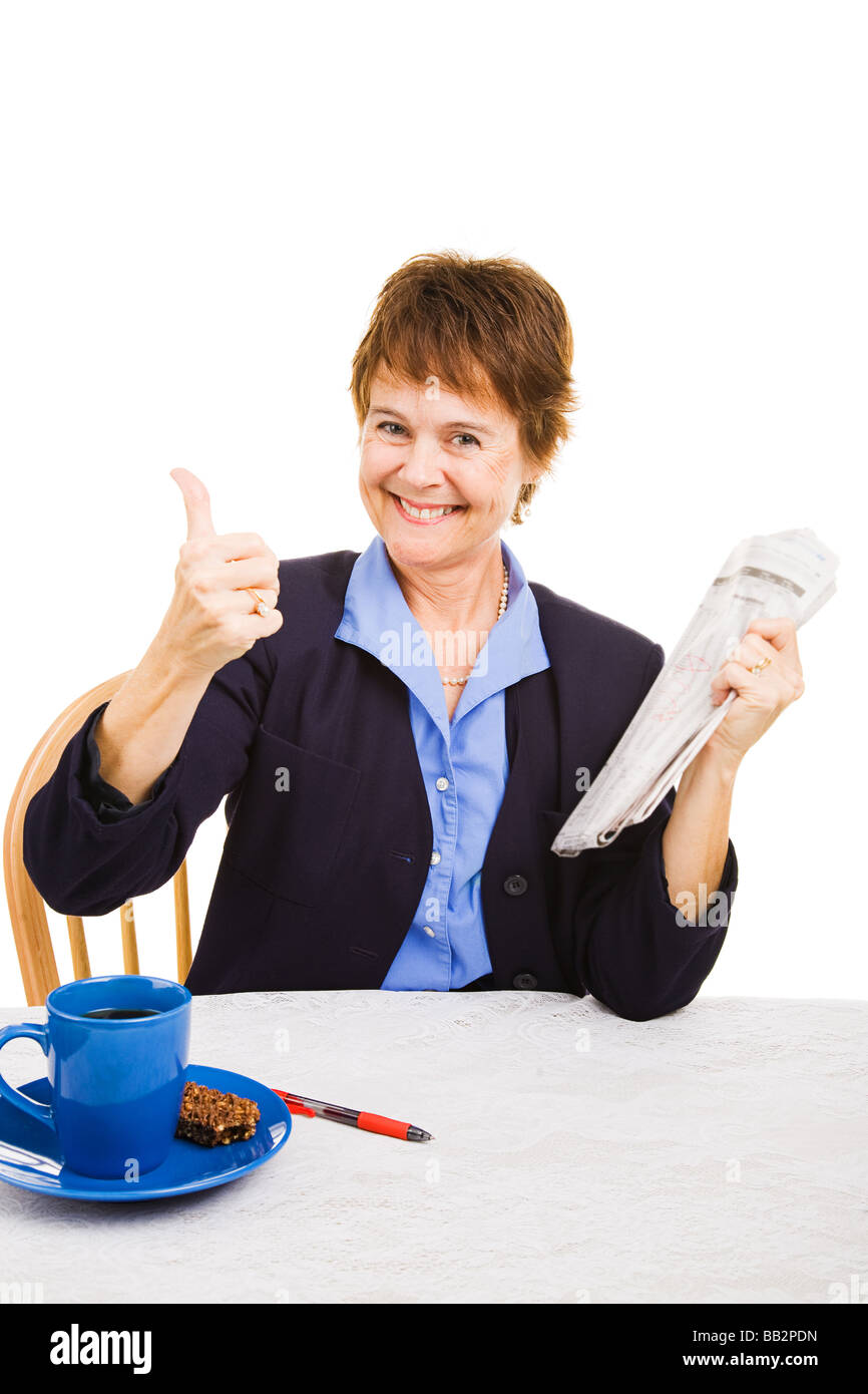 Mature woman looking for a job in the newspaper classified section is ...