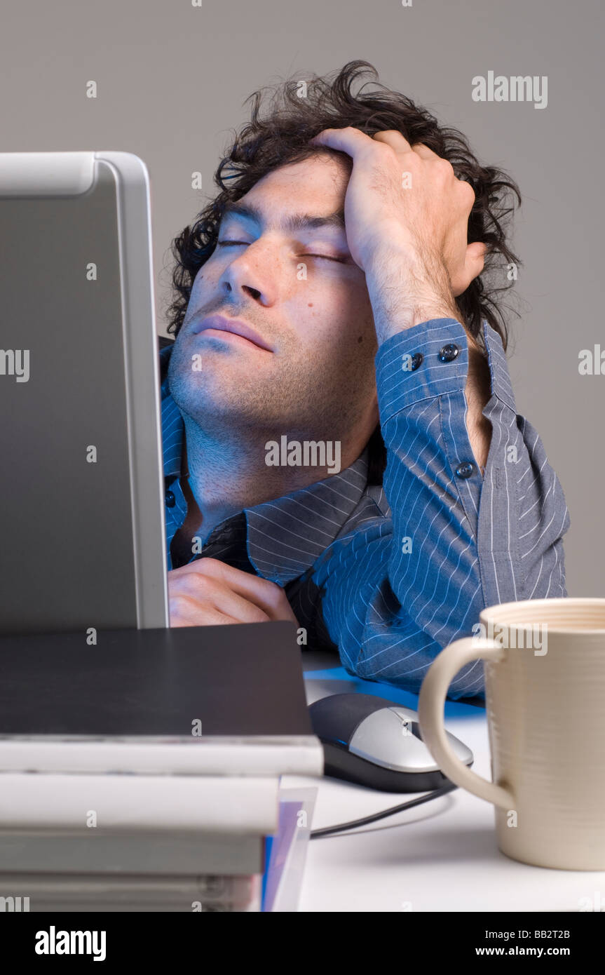 tired man at computer desk with coffe mug Stock Photo - Alamy
