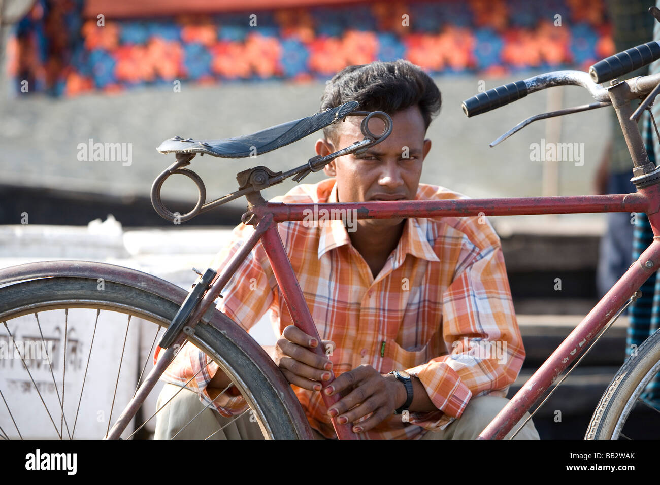 Daily Life in Bangladesh; Portrait of a man looking through a bicycle ...