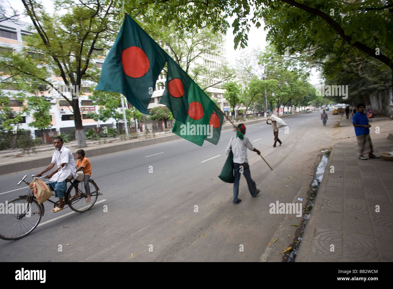 Daily Life in Bangladesh; a man carrying Bangladeshi flags passes a ...
