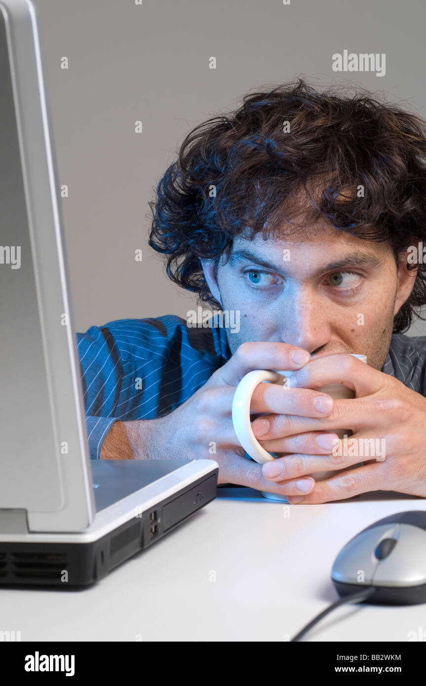 tired man at computer desk with coffe mug Stock Photo - Alamy