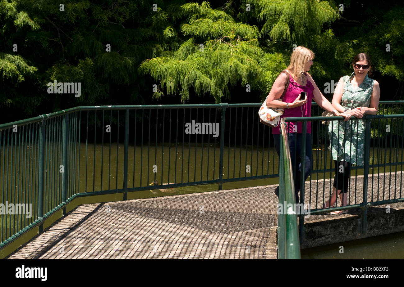 Mother and daughter standing on walkway over pond, Hamilton gardens ...