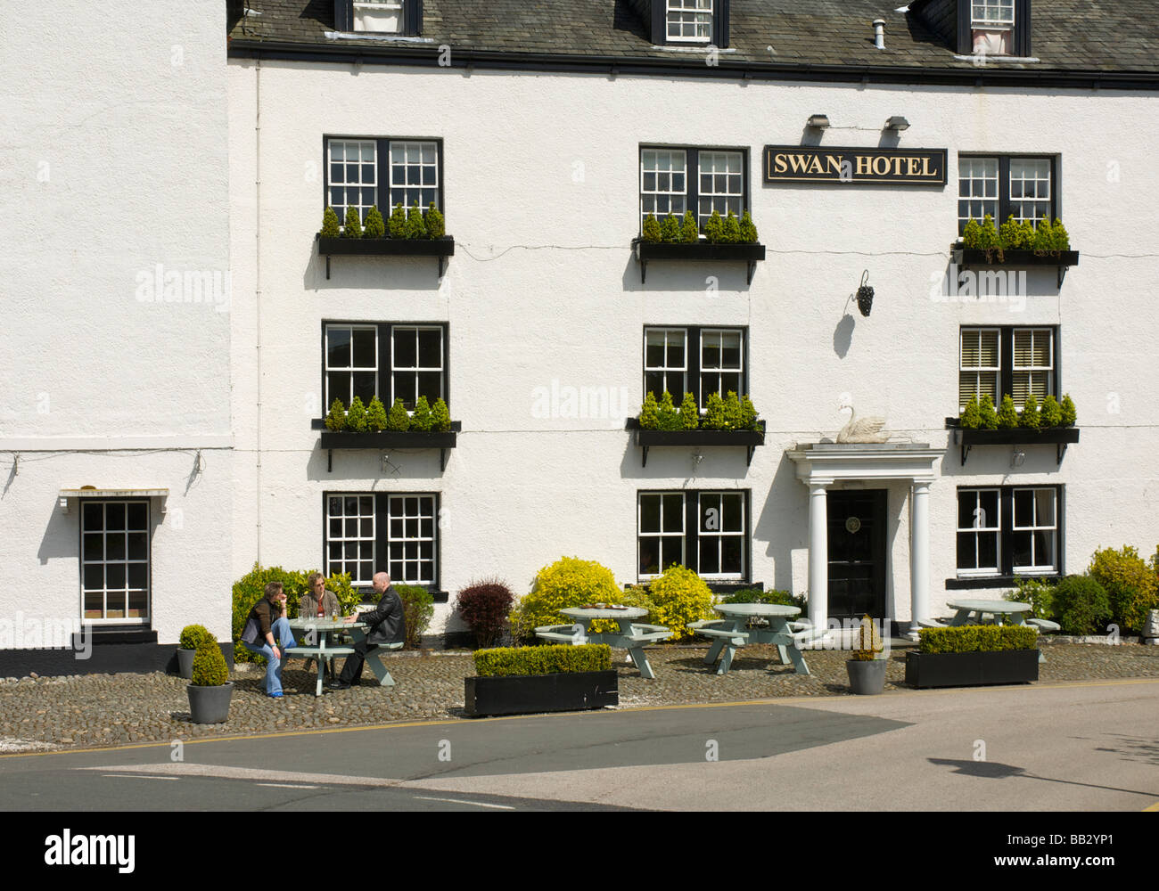Three people drinking outside the Swan Hotel, Newby Bridge, Lake ...