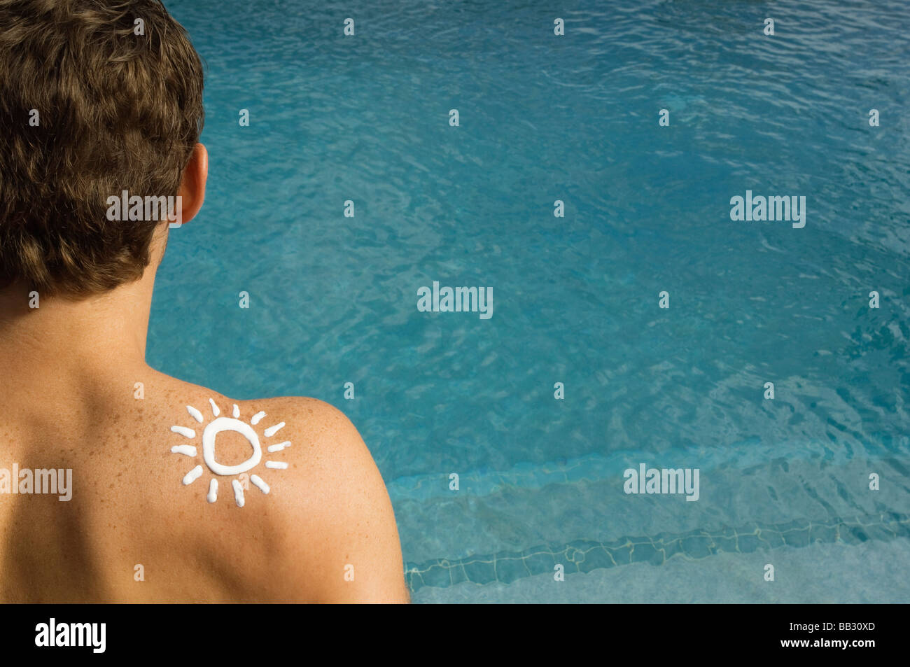 Man with sun shape on his shoulder at the poolside Stock Photo - Alamy