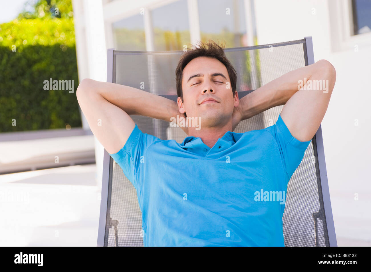 Man sleeping on a lounge chair Stock Photo - Alamy