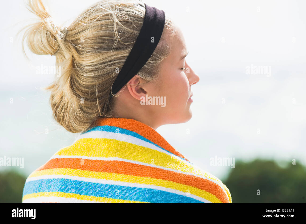 Rear view of a woman with a beach towel around shoulders Stock Photo ...