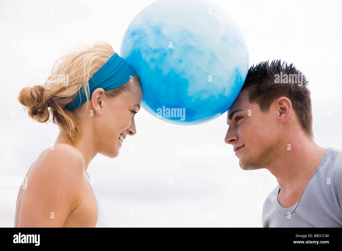 Couple balancing beach ball between their heads Stock Photo - Alamy