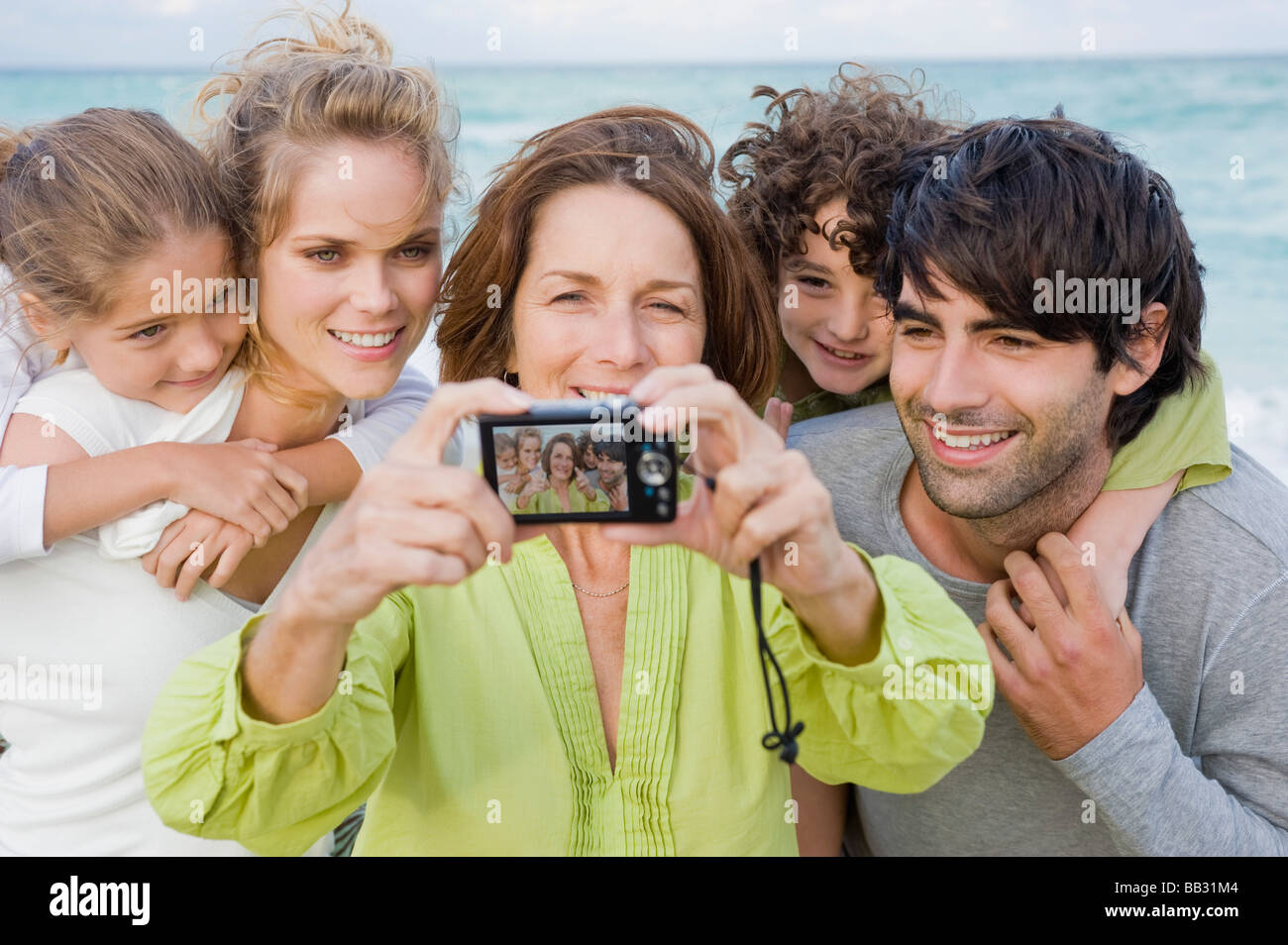 Woman taking a picture of her family with a digital camera Stock Photo ...