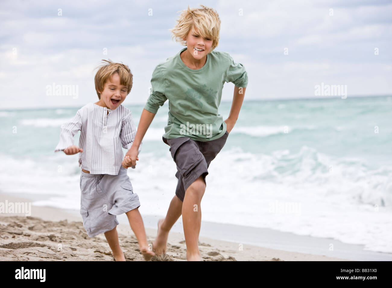Two boys running on the beach Stock Photo - Alamy