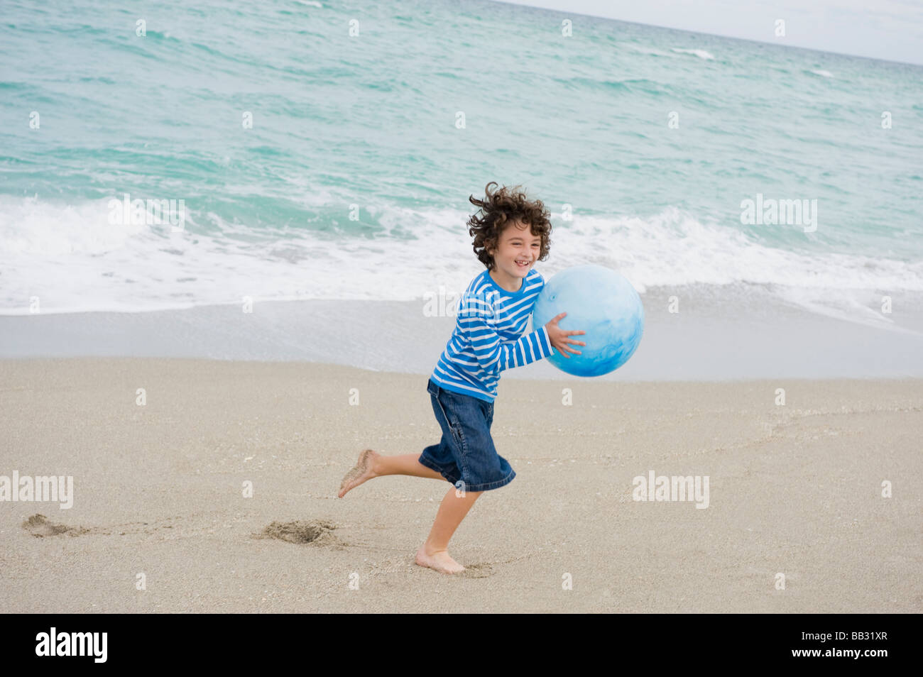 Boy playing on the beach Stock Photo - Alamy