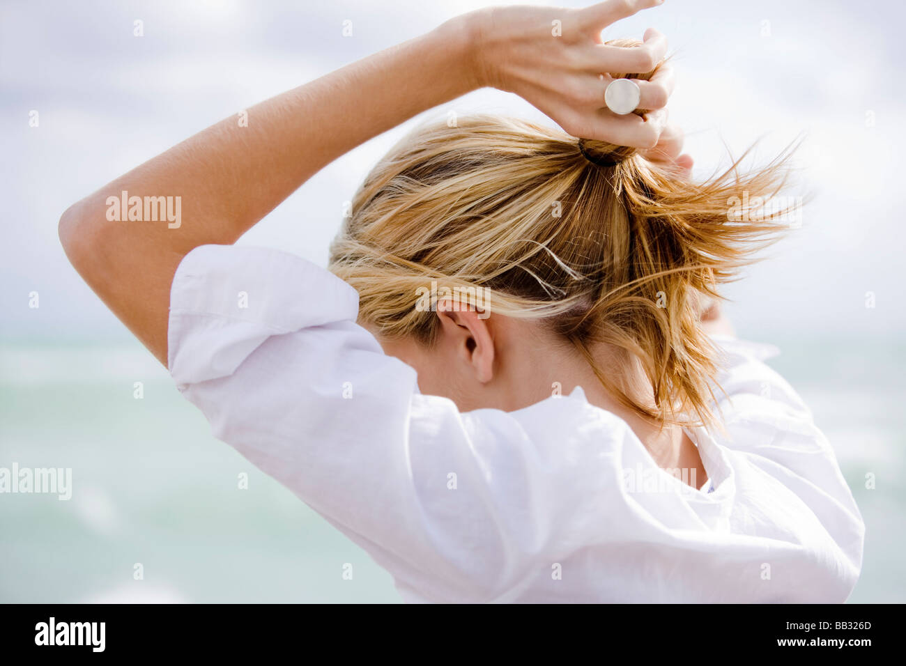 Woman setting hair in ponytail Stock Photo - Alamy