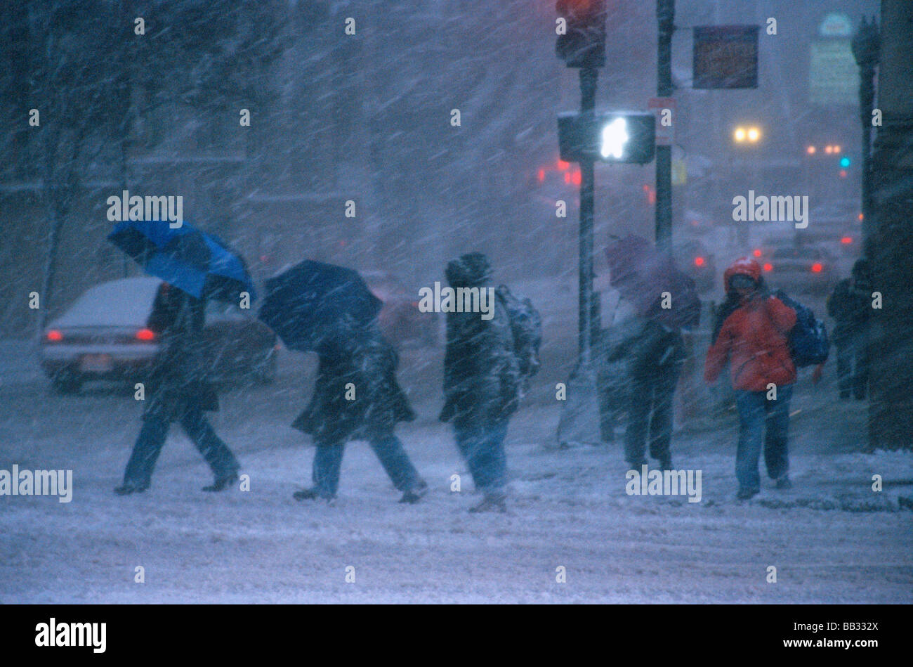 People struggle against the snow and wind in a severe thundersnow ...