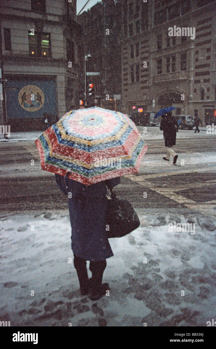 A woman with a brightly coloured umbrella in a severe thundersnow ...