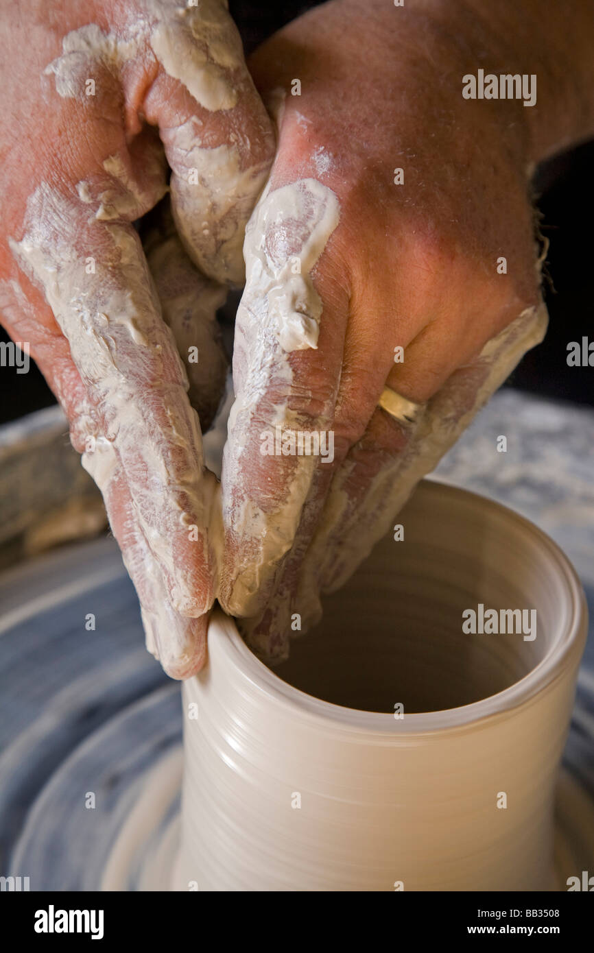 Potter's hands shape a new clay pot on a spinning wheel Stock Photo - Alamy