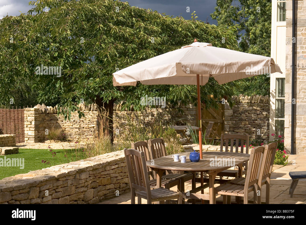 UK. A patio terrace garden table chairs and parasol sun shade Stock ...