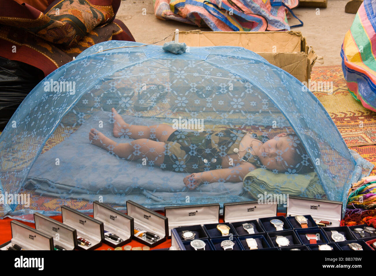 Young boy napping in net, street market, Luang Prabang, Northern Laos ...