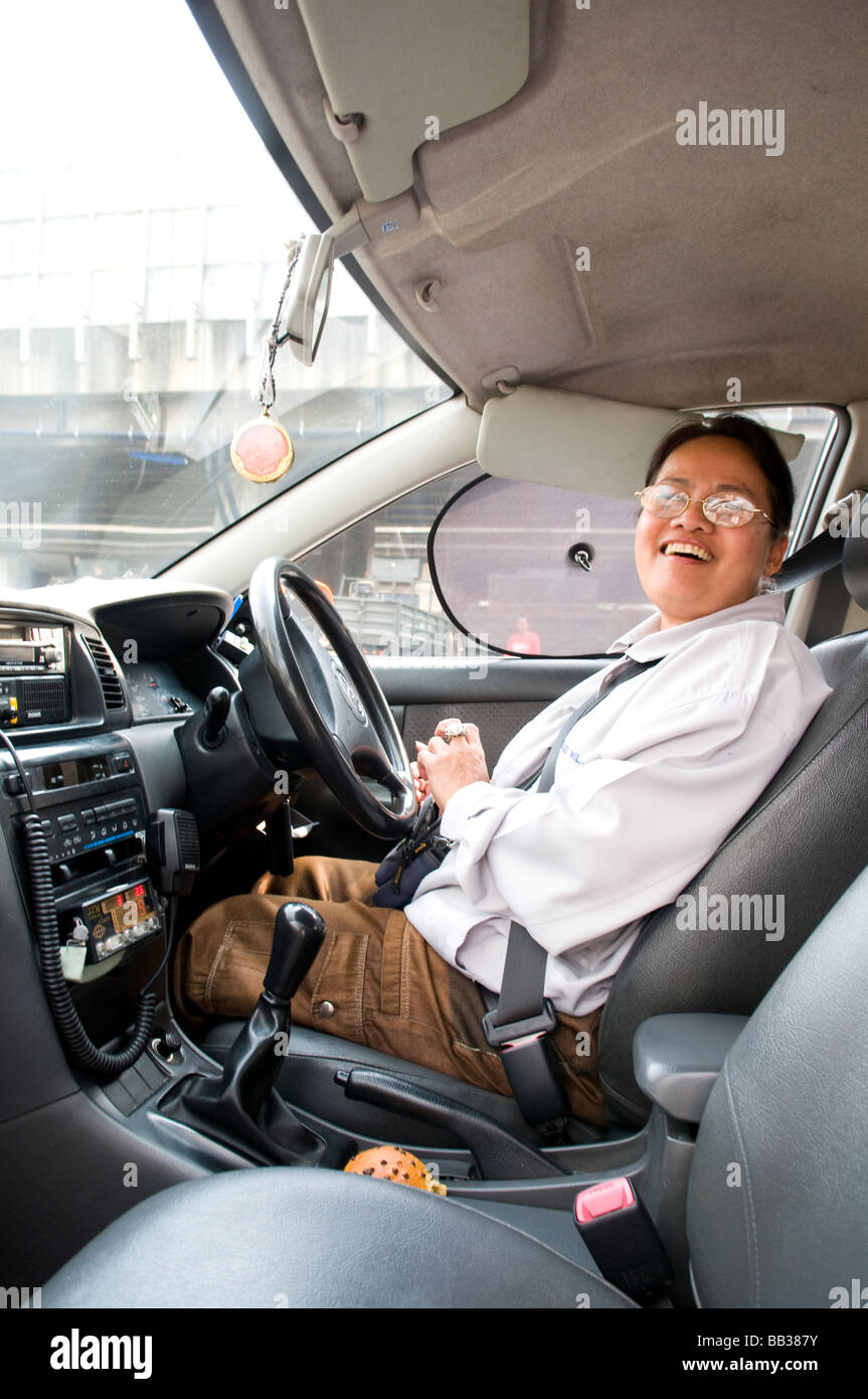Smiling and friendly female metered taxi driver in Bangkok, Thailand ...
