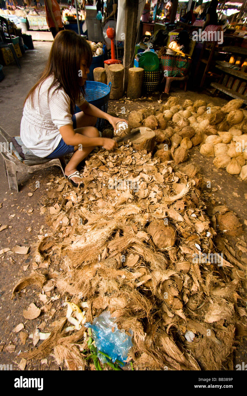 Young woman cracking coconuts, market, Vientiane, Capital of Laos ...