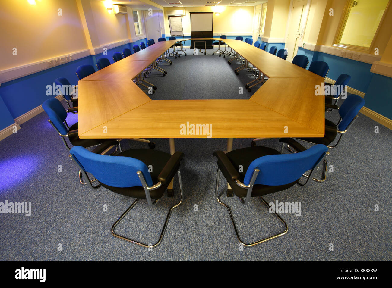 Large empty meeting room with blue chairs and wooden table Stock Photo ...