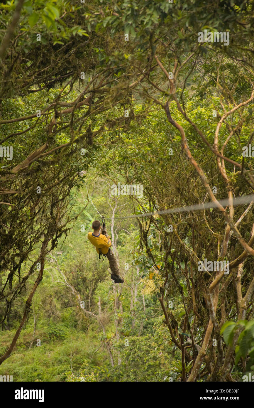 South America, Ecuador, Mindo. Boy tourist (age 9) and guide riding zip ...