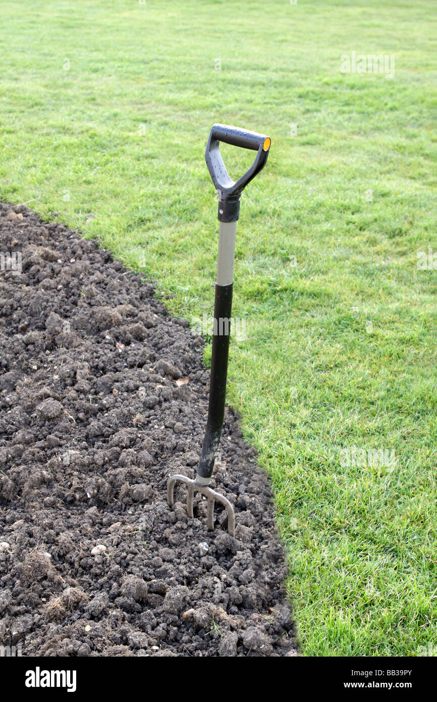 new garden planting bed showing recently dug ground with area of grass ...