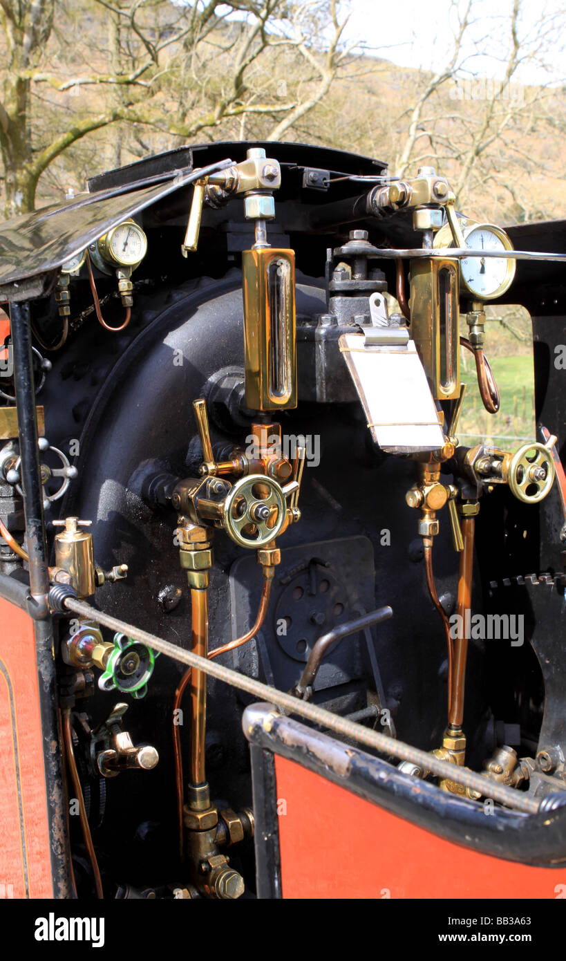inside view of cockpit operating controls of a small red steam train ...