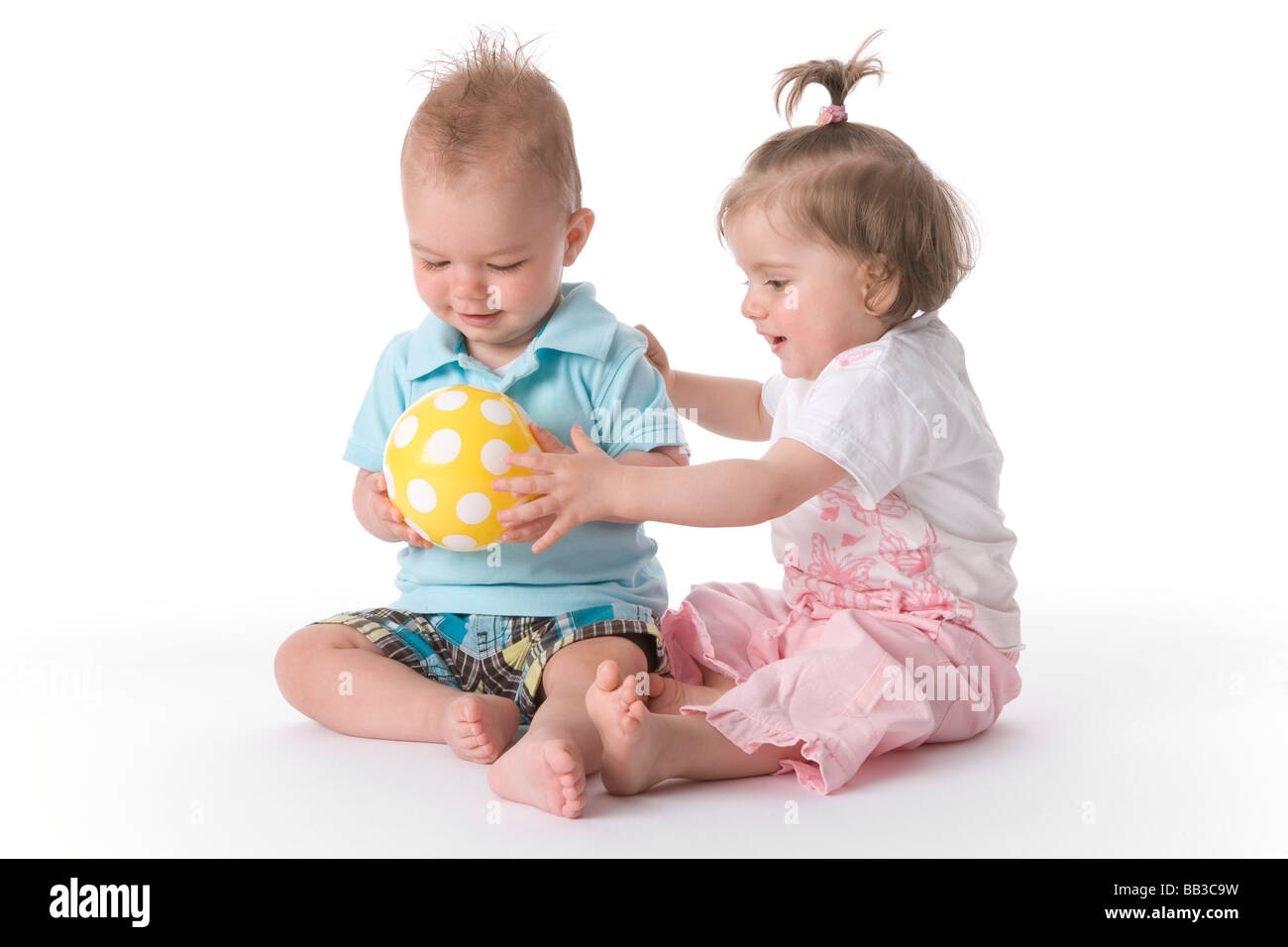 Two toddlers playing with a ball Stock Photo - Alamy