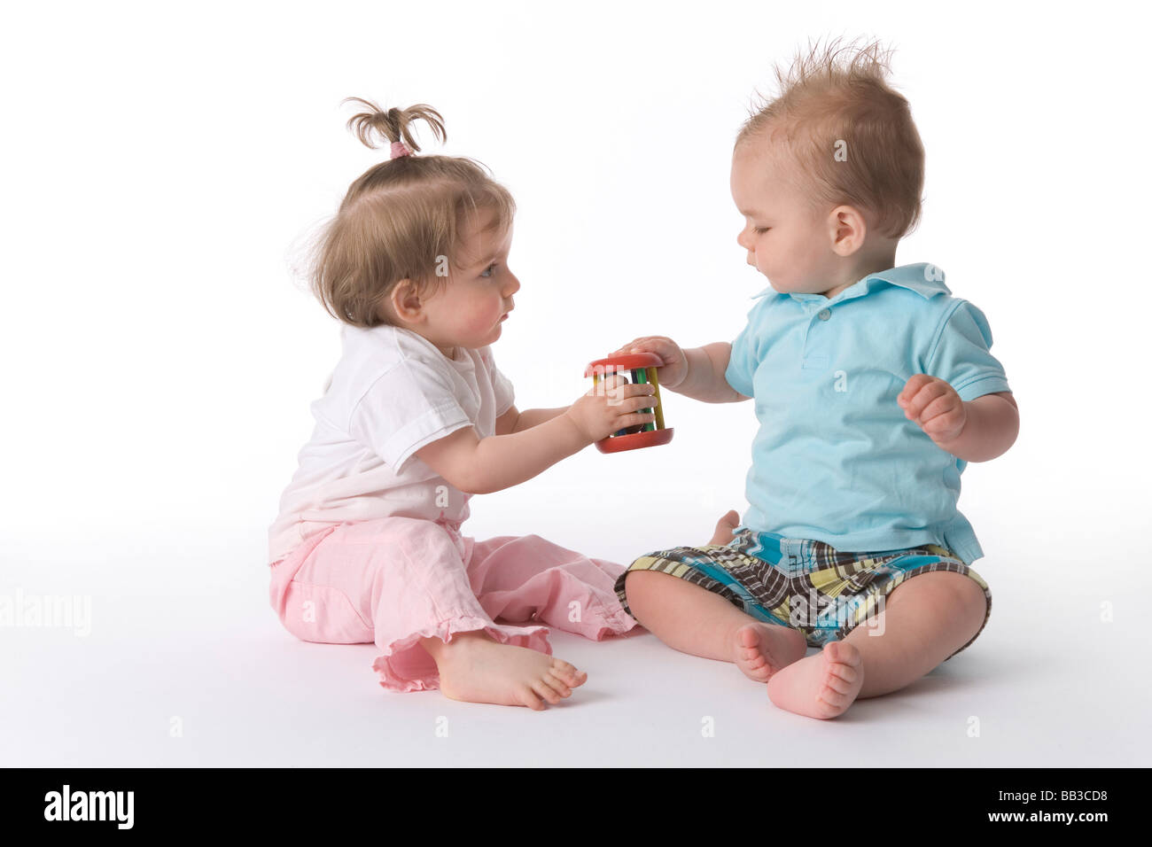 Two toddlers playing with a toy Stock Photo - Alamy