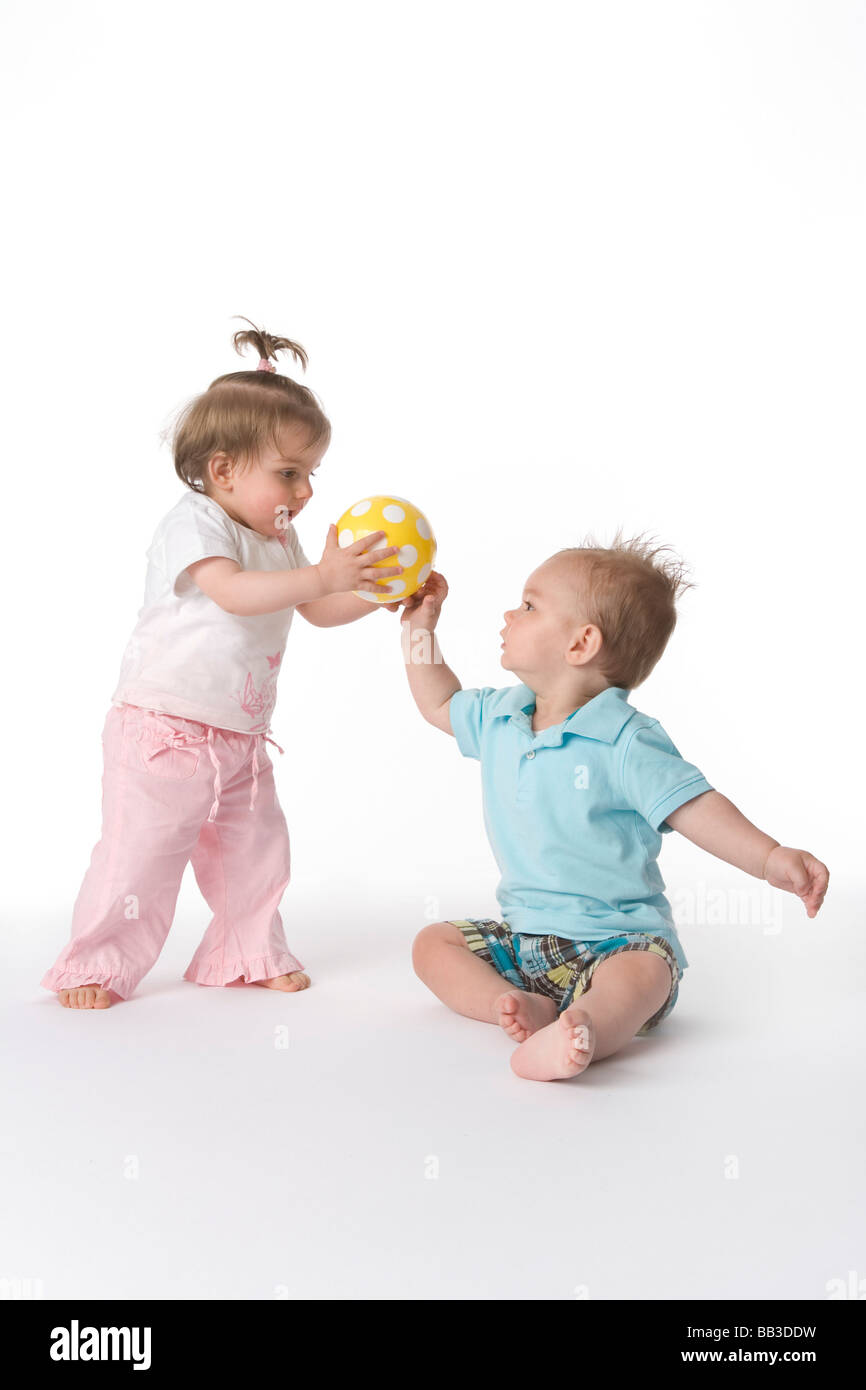 Two toddlers playing with a ball Stock Photo - Alamy