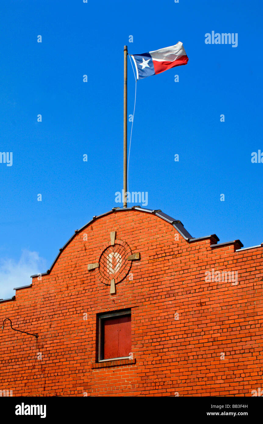 Texas state flag flies over a red brick architectural structure in the ...