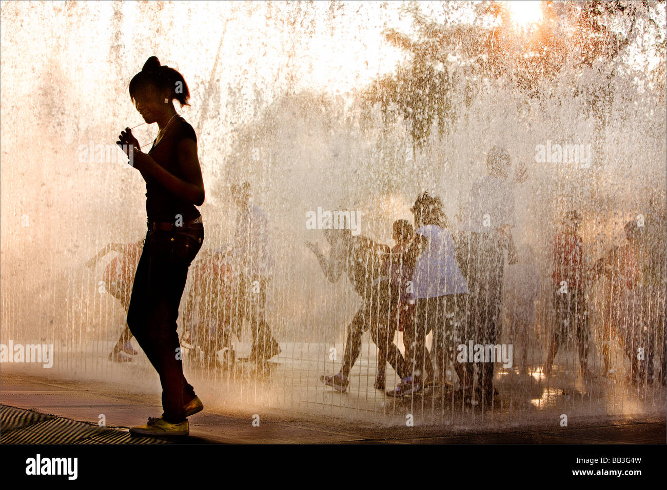 Adults and children playing in the water fountains at the Thames ...